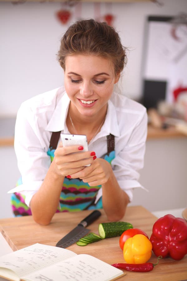 Smiling Woman Holding Her Cellphone in the Kitchen Stock Photo - Image ... Smiling Woman Holding Her Cellphone in the Kitchen Stock Photo - Image ...