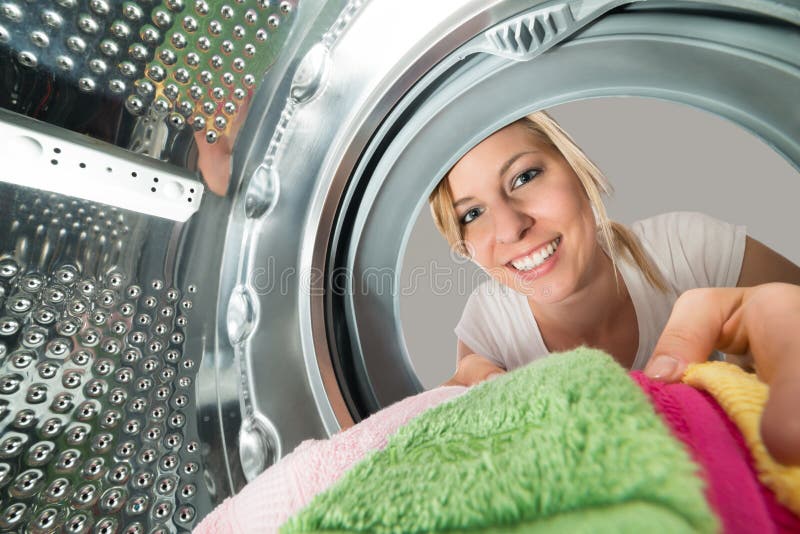 Smiling Woman Inserting Clothes in Washing Machine Stock Photo - Image ...