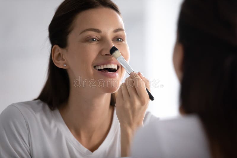 Smiling Woman Looking in Mirror, Applying Makeup with Brush Stock Image ... Smiling Woman Looking in Mirror, Applying Makeup with Brush Stock Image ...