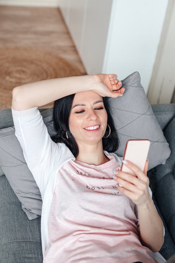 Smiling Woman Lying and Using Mobile Phone at Home Stock Photo - Image ...