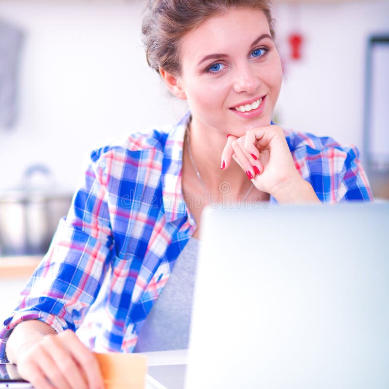 Smiling Woman Online Shopping Using Computer and Credit Card in Kitchen ...