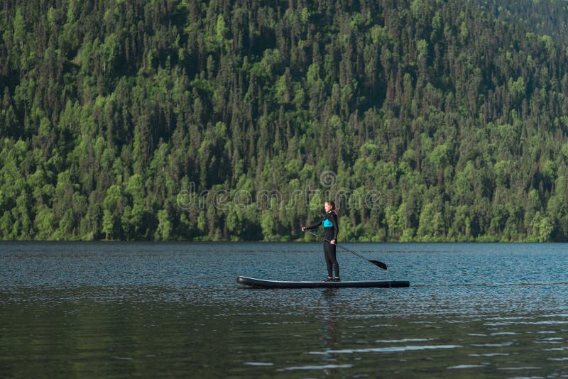Smiling Woman Paddleboarding on the Mountain Lake Stock Photo - Image ...