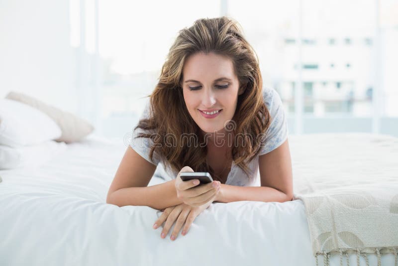 Smiling Woman Resting in Bed Text Messaging Stock Photo - Image of ...