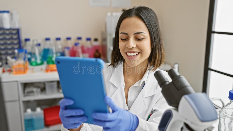 Smiling Woman Scientist Using Tablet in Laboratory with Microscope and ...