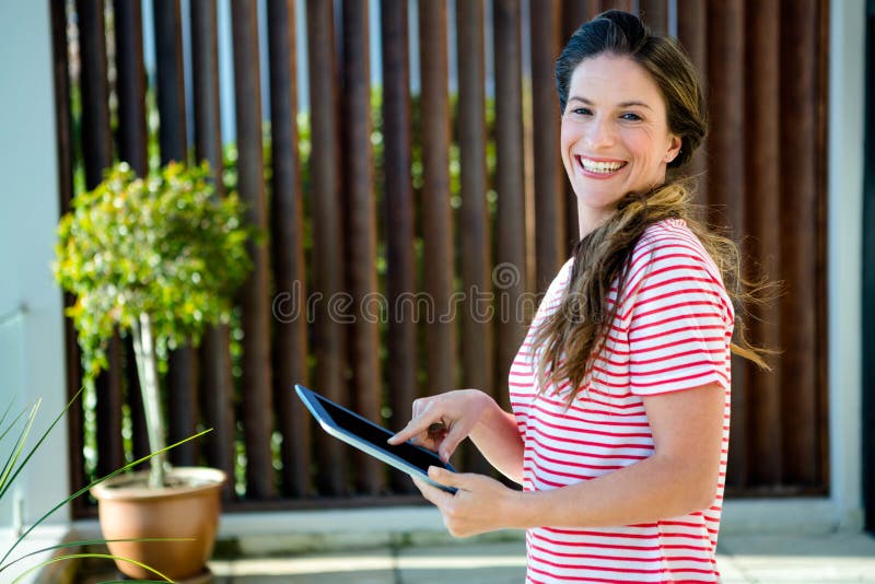 Smiling Woman Scrolling on Her Tablet Stock Photo - Image of typing ...