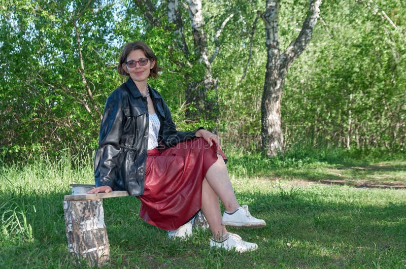 Smiling Woman Sitting on a Makeshift Bench in a Forest Clearing Stock ...