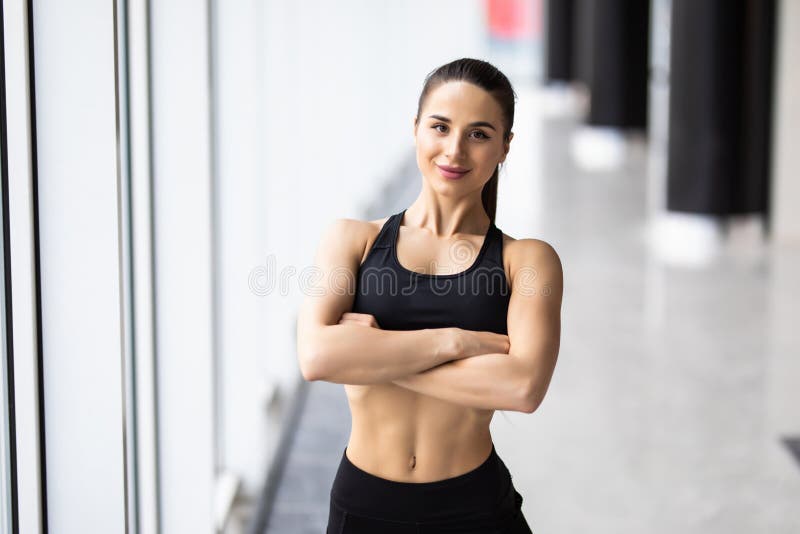 Smiling Sports Woman Standing with Arms Folded and Looking at Camera at ... Smiling Sports Woman Standing with Arms Folded and Looking at Camera at ...