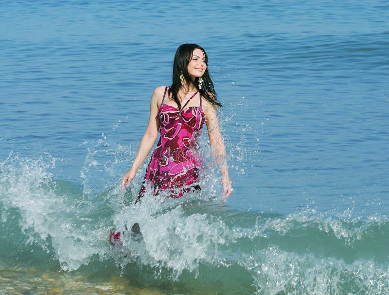 Smiling Woman Standing in Sea Waves Stock Photo - Image of dress ...