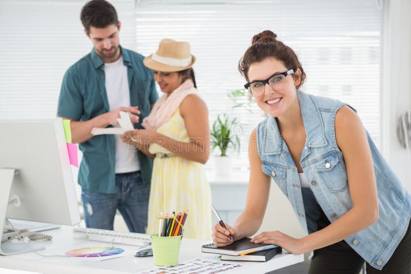 Smiling Woman Taking Note in Front of Her Colleagues Stock Photo ...