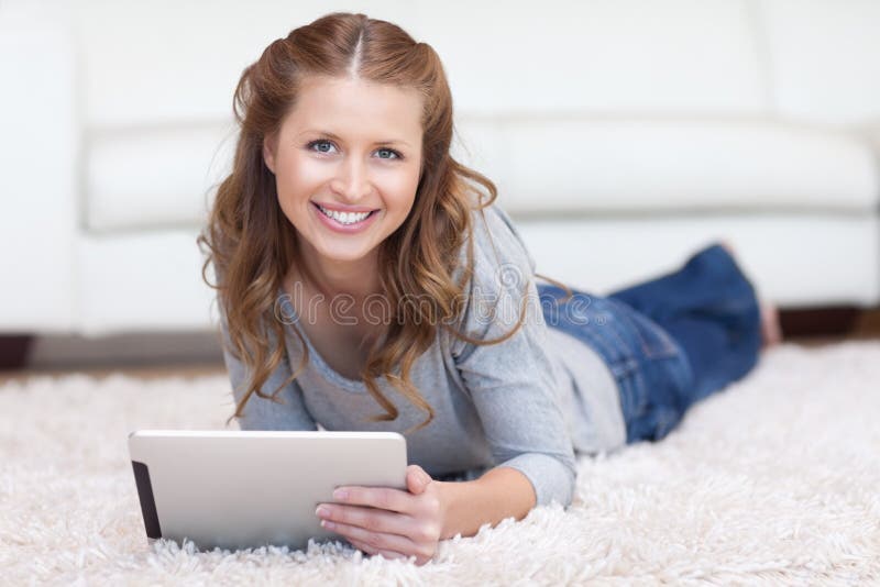 Smiling Woman Using Her Tablet on the Floor Stock Photo - Image of ...