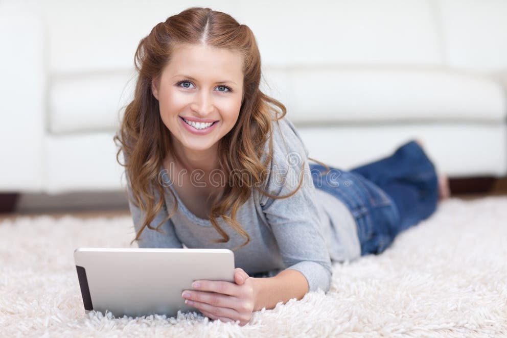 Smiling Woman Using Her Tablet on the Floor Stock Photo - Image of ...