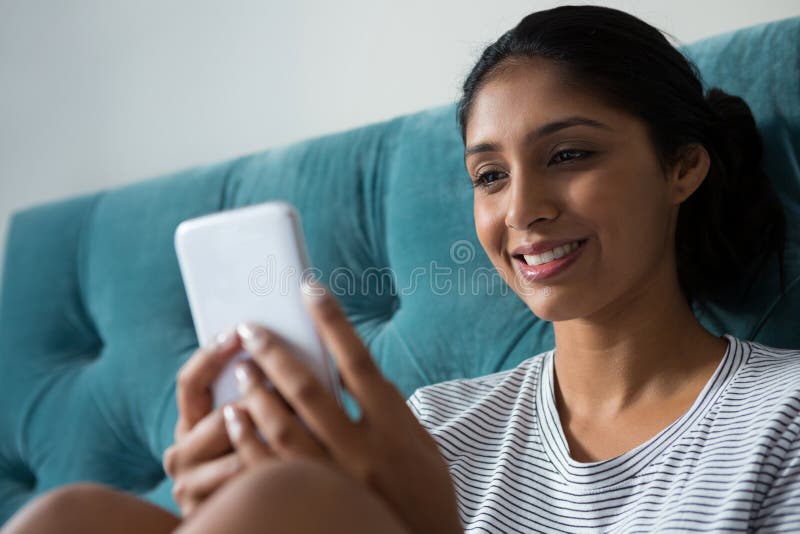 Smiling Woman Using Phone in Bedroom Stock Photo - Image of mobile ...