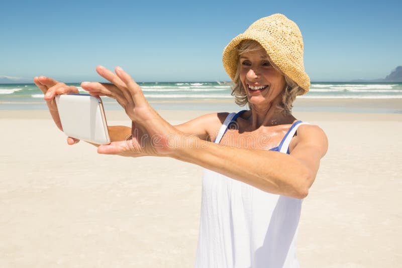 Smiling Woman Using Smart Phone while Standing at Beach Stock Image ...