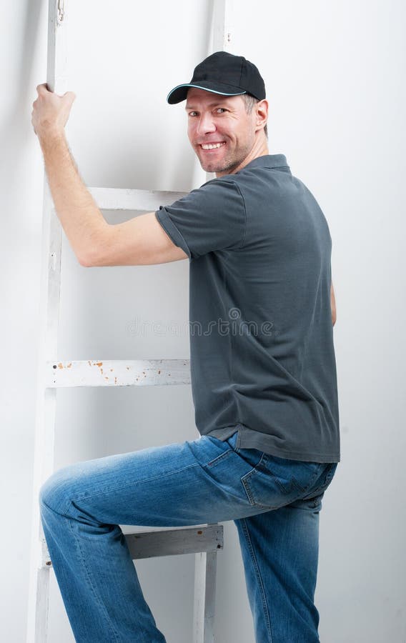 Smiling Worker Man Hold A Ladder On White Background Stock Photo ...
