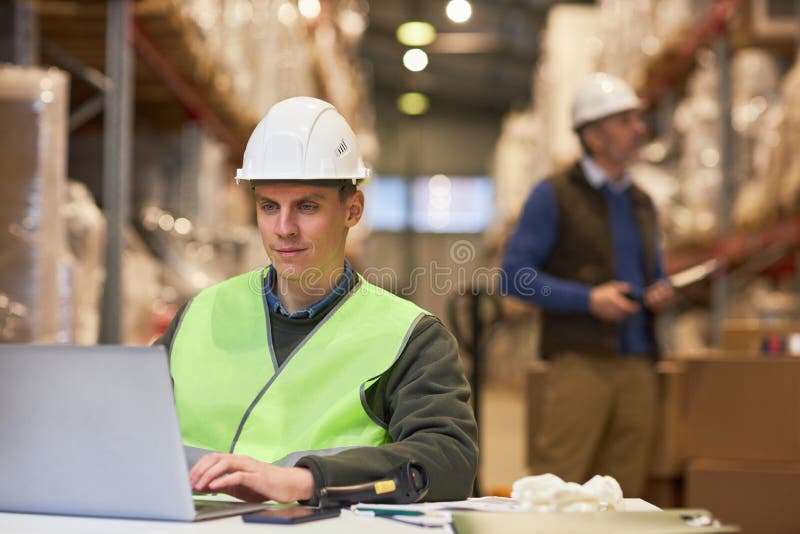 Smiling Worker Using Laptop in Warehouse Managing Distribution System ...