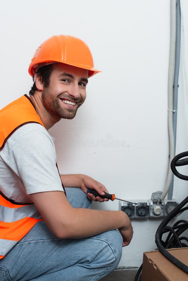 Smiling Workman Holding Screwdriver Near Sockets. Stock Photo - Image ...