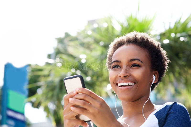 Smiling Young African Woman Listening To Music With Earphones Stock