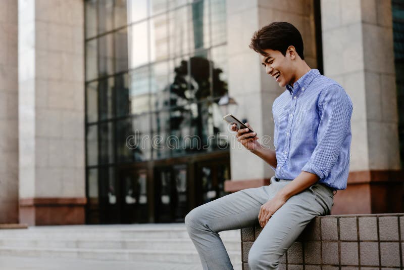 Smiling Young Asian Businessman Using Mobile Phone Stock Photo - Image ...