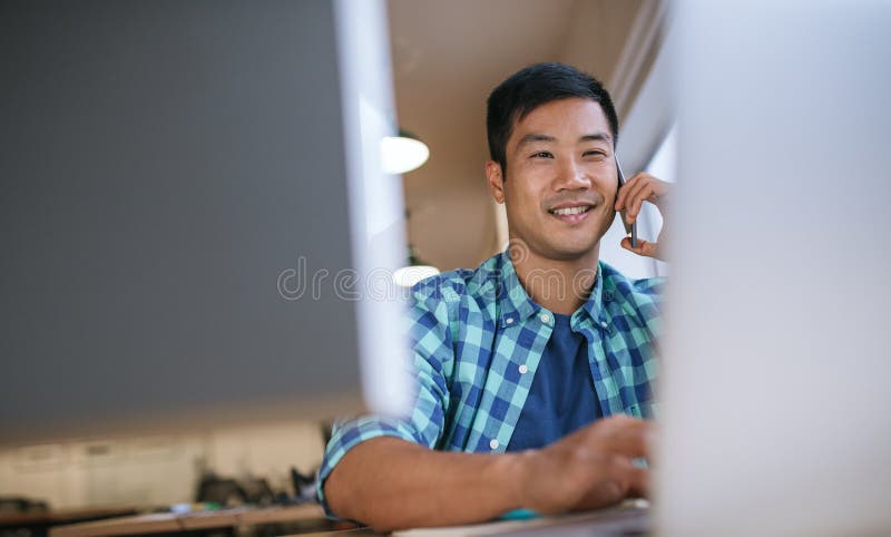 Smiling Asian Designer Working at His Desk in an Office Stock Image ...