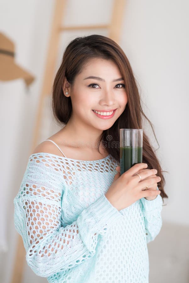 Smiling Young Asian Woman Drinking Green Fresh Vegetable Juice O Stock