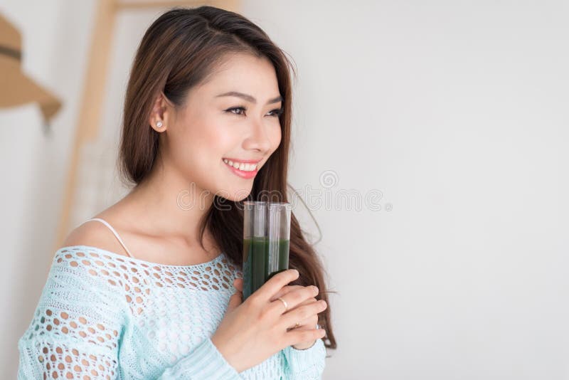 Smiling Young Asian Woman Drinking Green Fresh Vegetable Juice O Stock