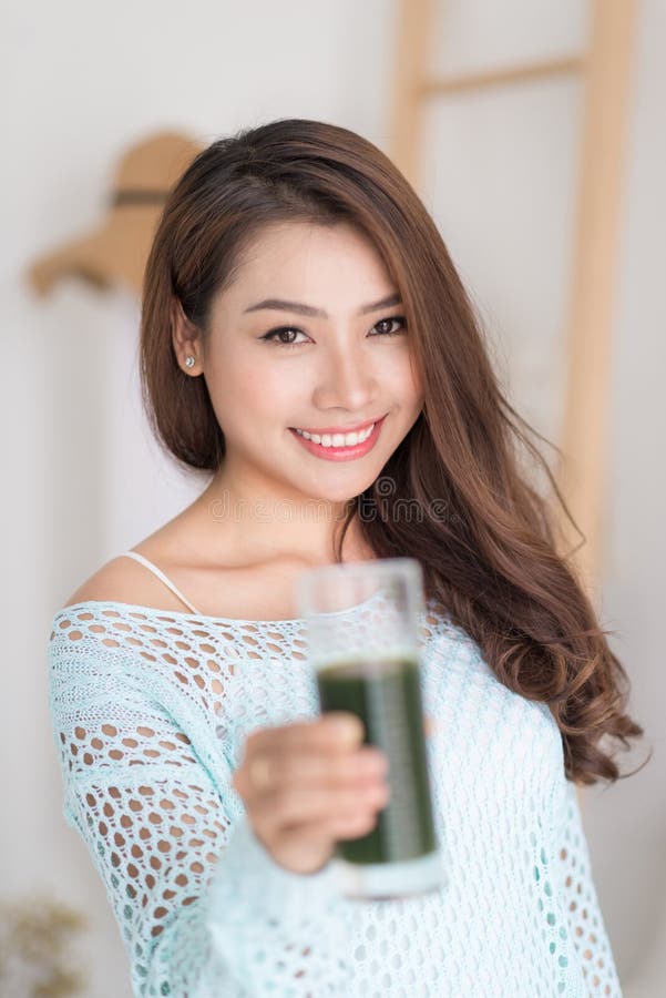 Smiling Young Asian Woman Drinking Green Fresh Vegetable Juice O Stock