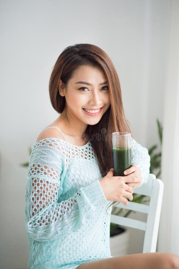 Smiling Young Asian Woman Drinking Green Fresh Vegetable Juice O Stock