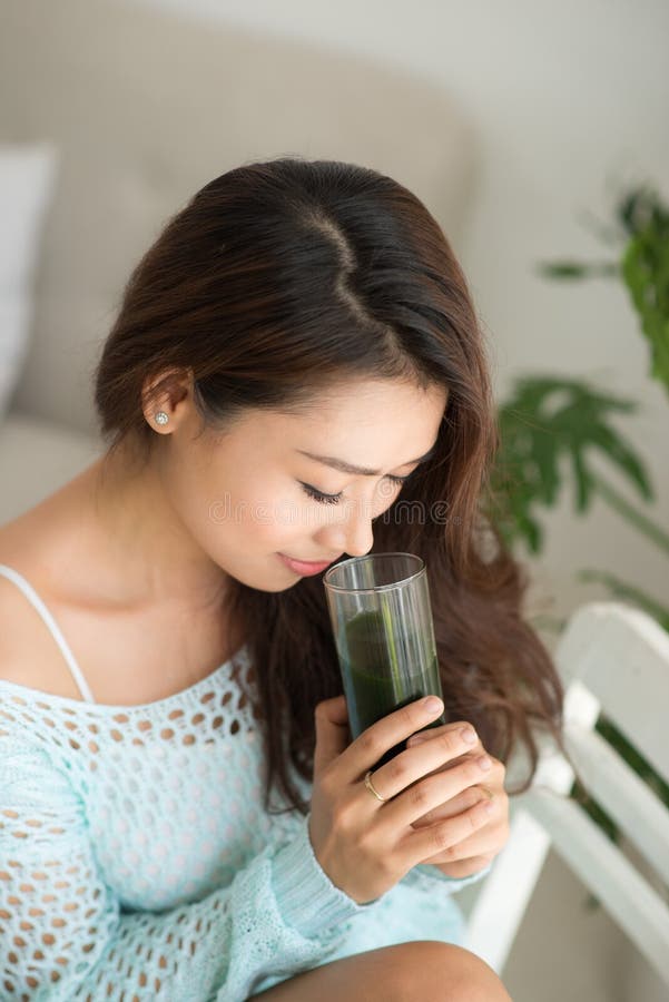 Smiling Young Asian Woman Drinking Green Fresh Vegetable Juice O Stock