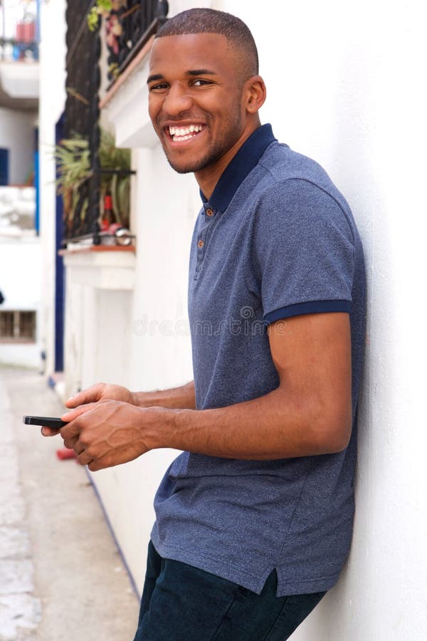 Smiling Young Black Man with Mobile Phone Standing Outside Stock Image ...