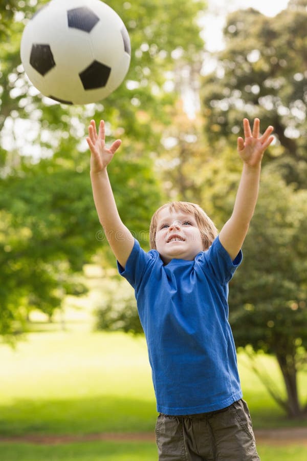 Smiling Young Boy Playing with Ball in Park Stock Photo - Image of ...