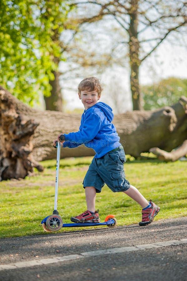 Smiling Young Boy on a Scooter Stock Image - Image of lifestyle, helmet ...
