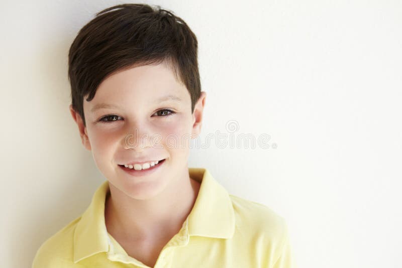 Smiling Young Boy Standing Outdoors Against White Wall Stock Photo ...