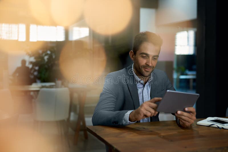 Smiling Young Businessman Using a Tablet at His Office Desk Stock Photo ...