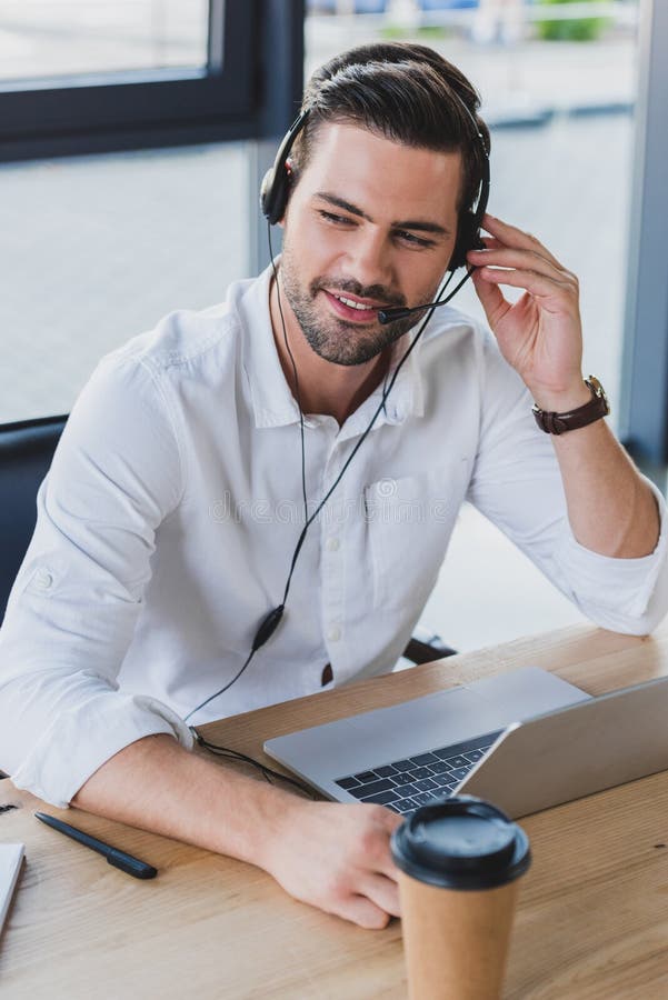 Smiling Young Call Center Operator in Headset Using Laptop Stock Photo ...