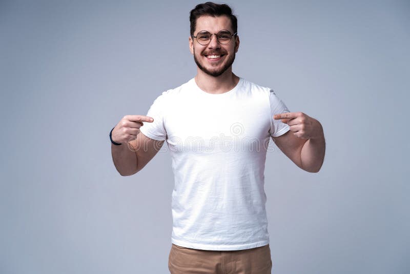 Smiling Young Casual Man Presenting Something on Gray Background. Stock ... Smiling Young Casual Man Presenting Something on Gray Background. Stock ...