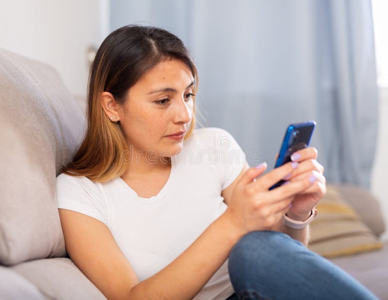 Smiling Young Colombian Female Chatting In Mobile Phone On Sofa Stock Image Image Of Person