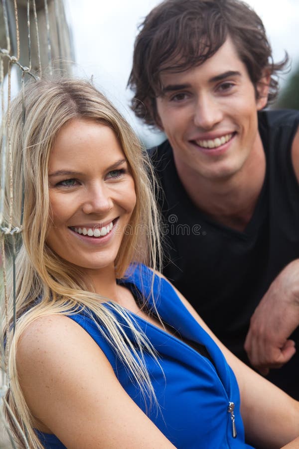 Smiling Young Couple by Fence Stock Image - Image of attractive, camera ...