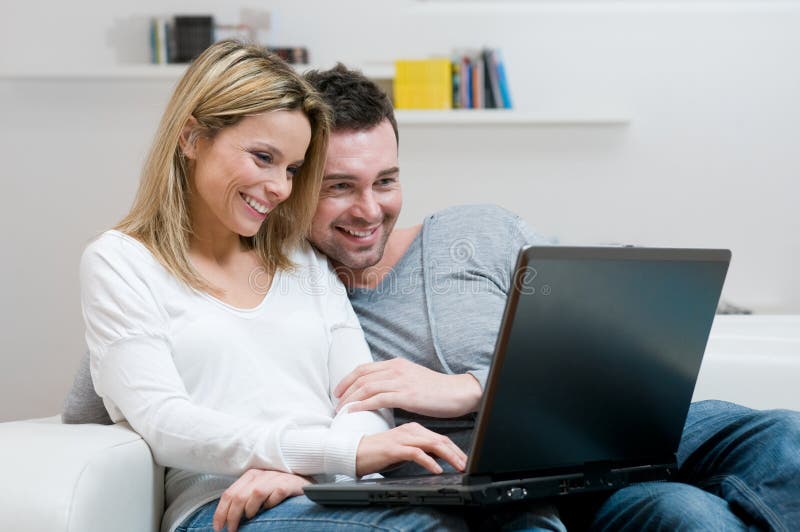 Couple in Living Room Using Laptop Smiling Stock Photo - Image of ...