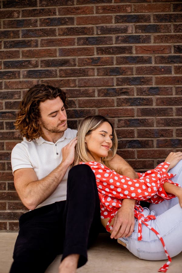 Smiling Young Couple in Love in Front of House Brick Wall Stock Photo ...