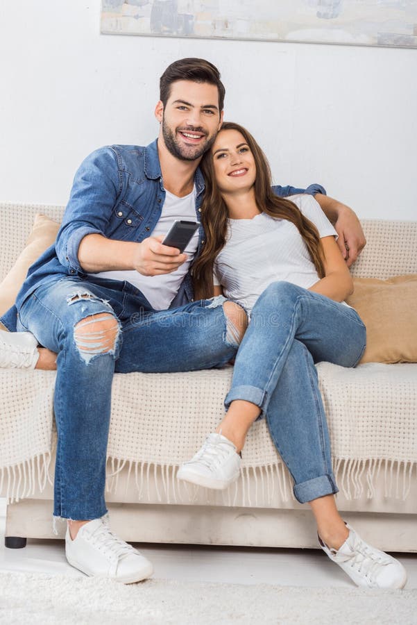 Smiling Young Couple with Remote Controller Watching Tv on Couch Stock ...
