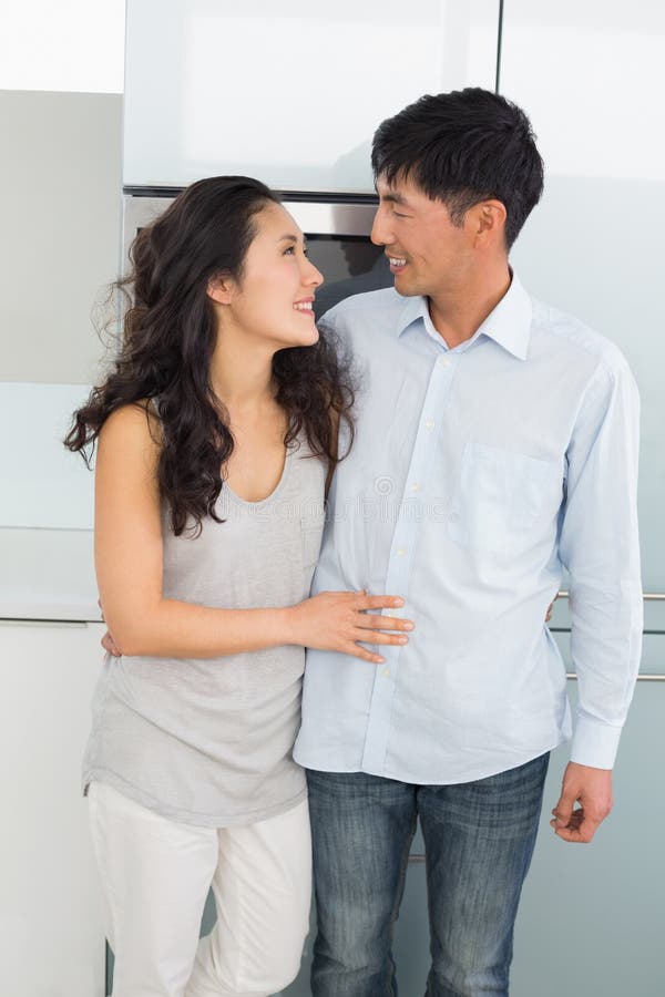 Smiling Young Couple Standing in the Kitchen Stock Photo - Image of ...