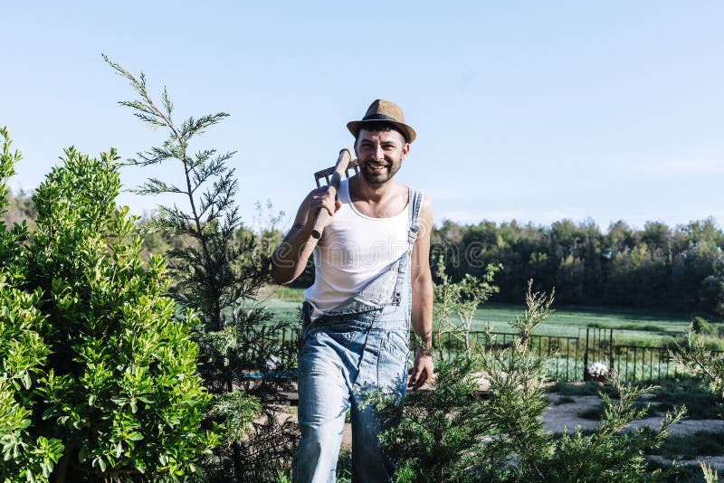 Smiling Young Farmer Man Standing in the Garden while Looking Away ...