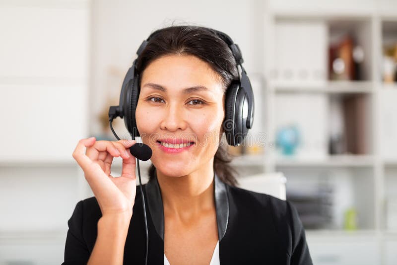 Smiling Young Female Operator Talking with Customer Using Headset at ...