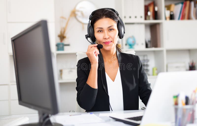 Smiling Young Female Operator Talking with Customer Using Headset at ...