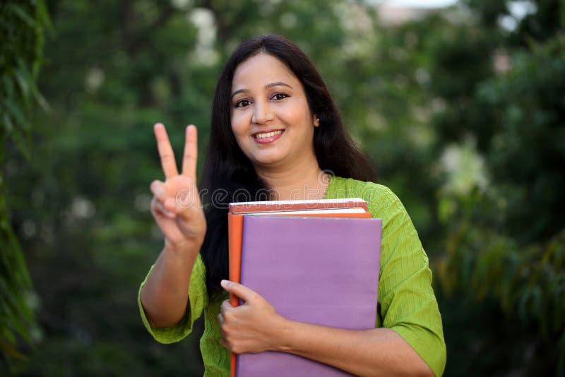 Smiling Young Female Student Making Victory Sign Stock Photo - Image of ...