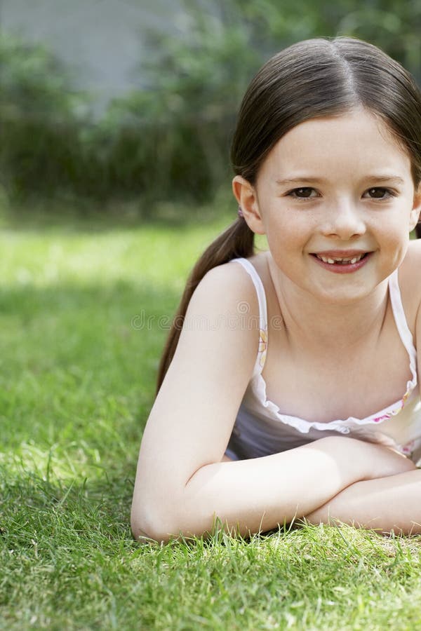 Smiling Young Girl Lying in Grass Stock Photo - Image of children ...