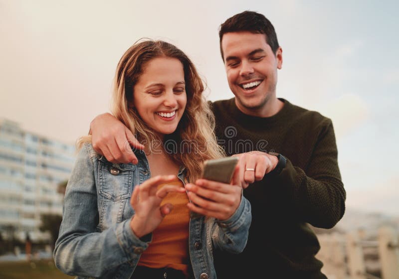 Smiling Young Group of Friends Using Mobile Device Apps, Surfing ...