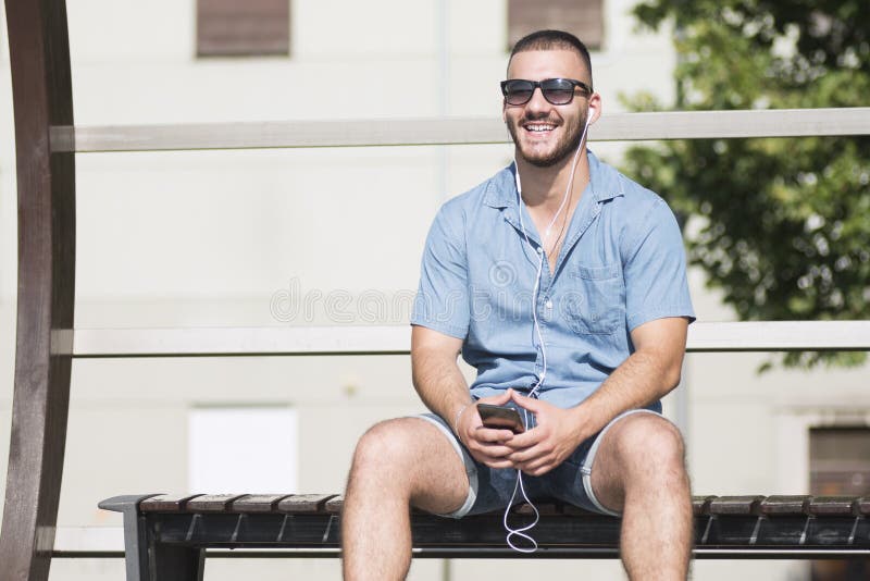 Smiling Young Guy Sitting on Bench Stock Image - Image of sitting ...