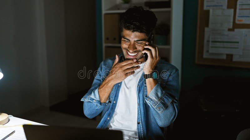 Smiling Young Hispanic Man Making a Phone Call at Night in a Modern ...