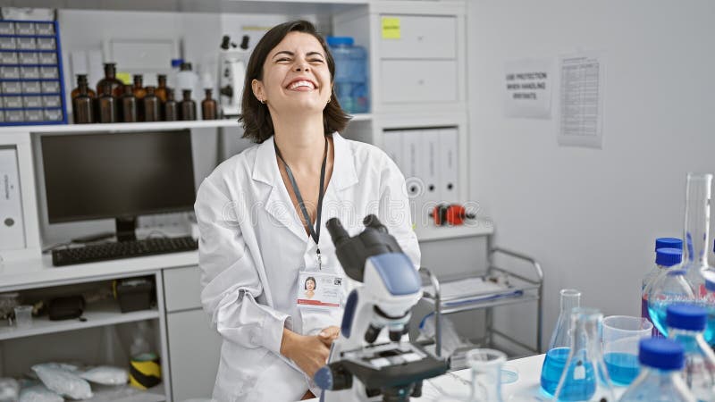 Smiling Young Hispanic Woman Scientist Joyfully Working with Microscope ...